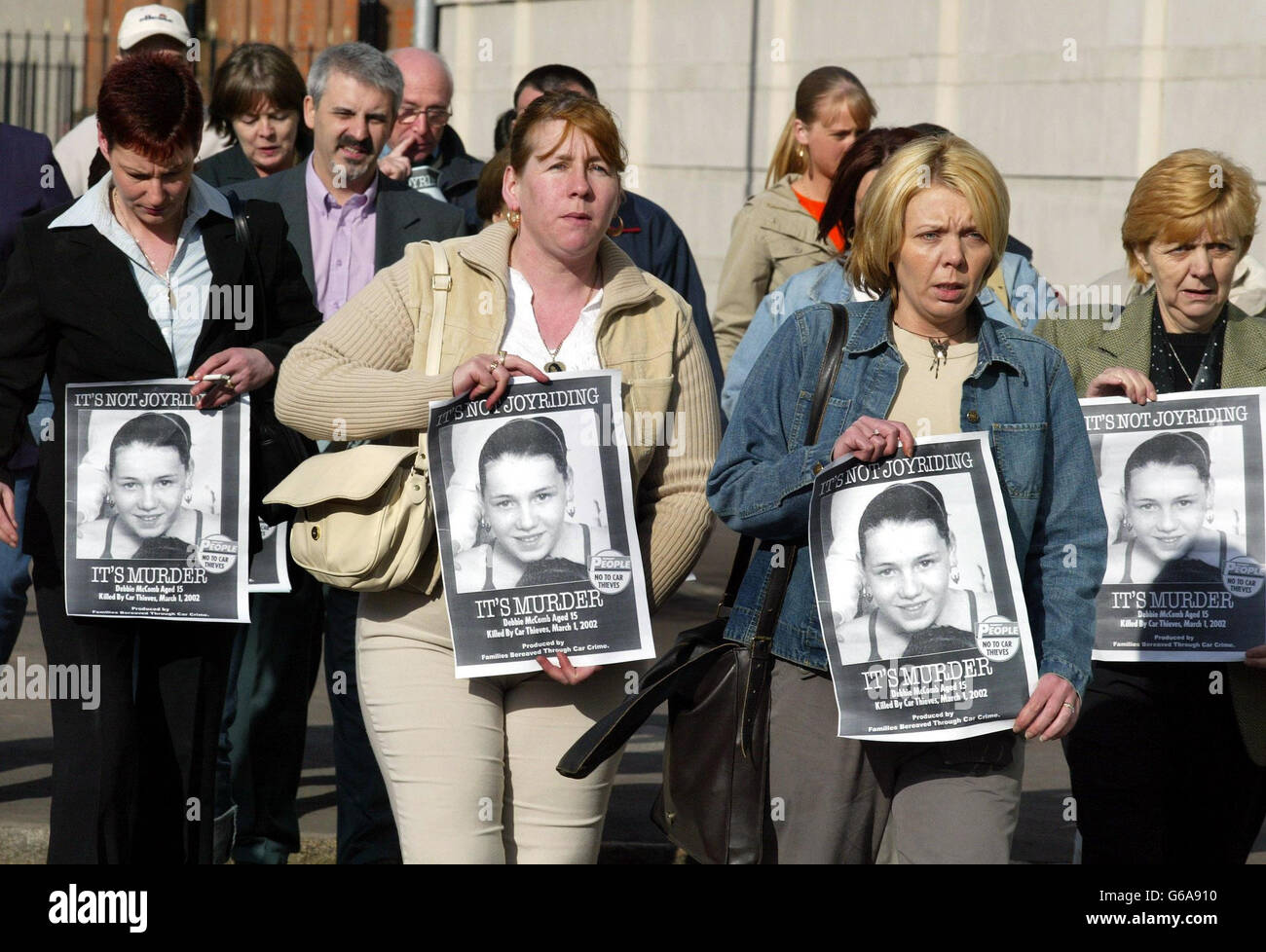 Mary McComb (2nd left) stands with family and friends, carrying a ...