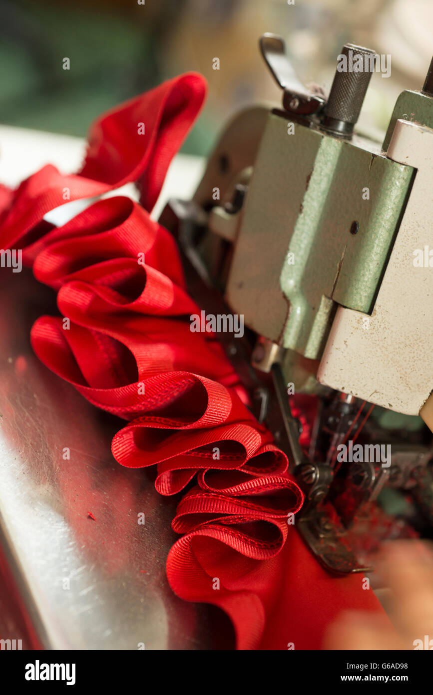 Red cloth and ribbon stitched and ruffled through a sewing machine ...
