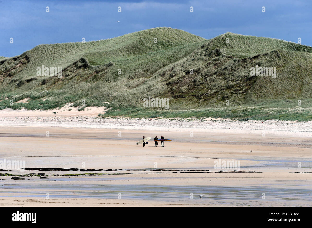 Surfers walk along Dunnet Beach, near Dunnet Head, the most northerly ...