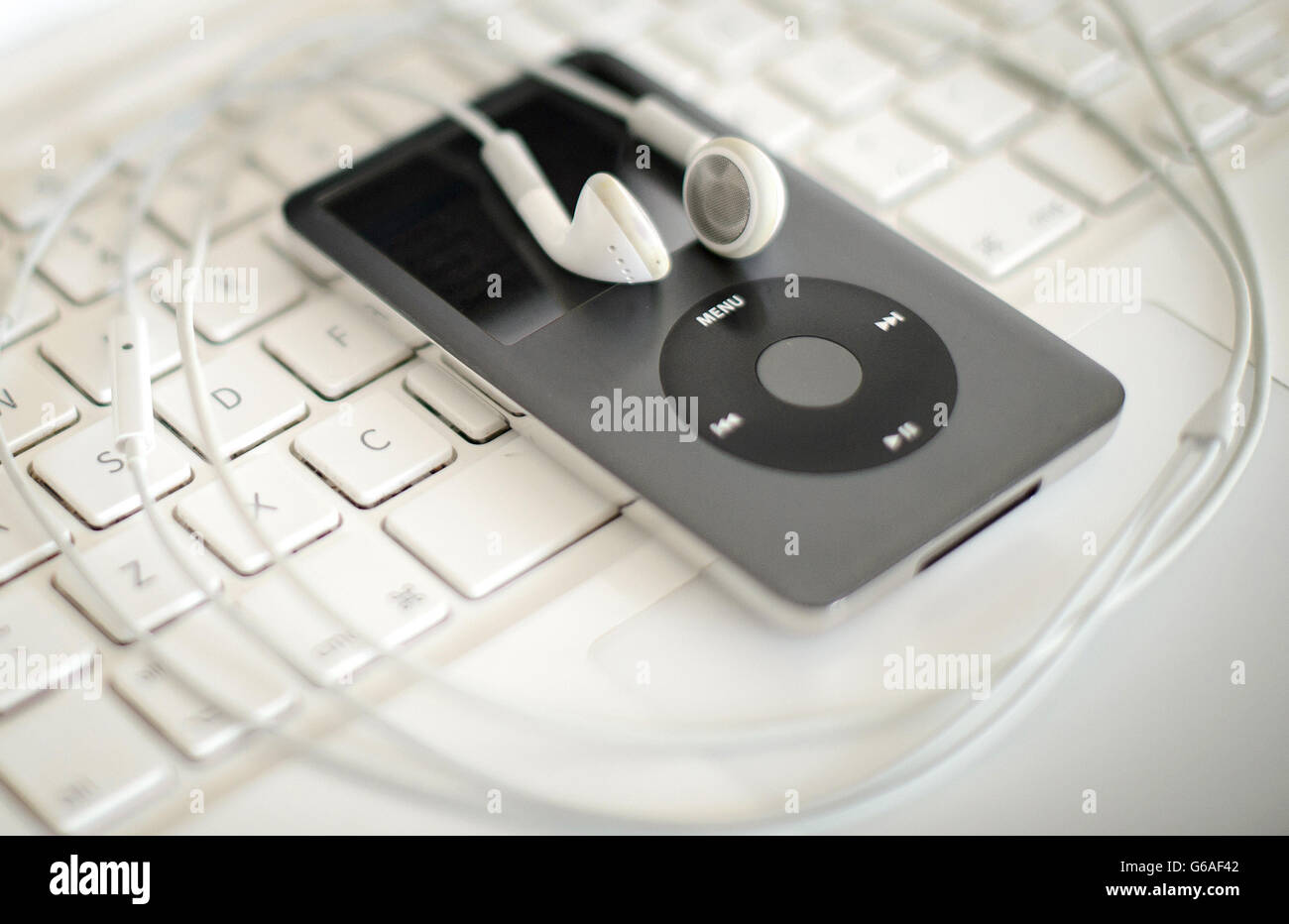 Generic stock photo shows an Apple iPod mp3 player sitting on a laptop ...