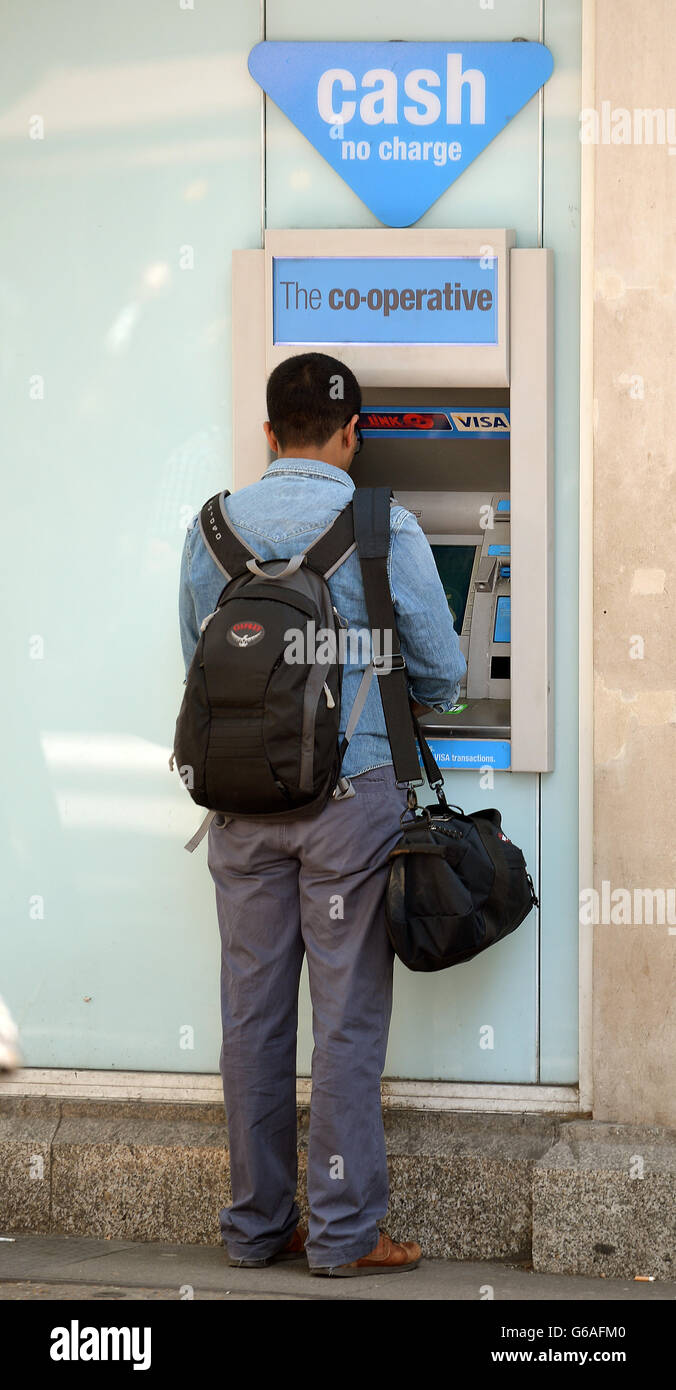 A customer uses the cashpoint machine outside a co-operative bank ...
