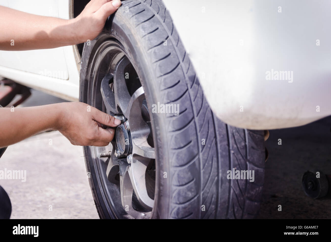 Hands of mechanic pick up the nut of car wheel and tighten Stock Photo ...