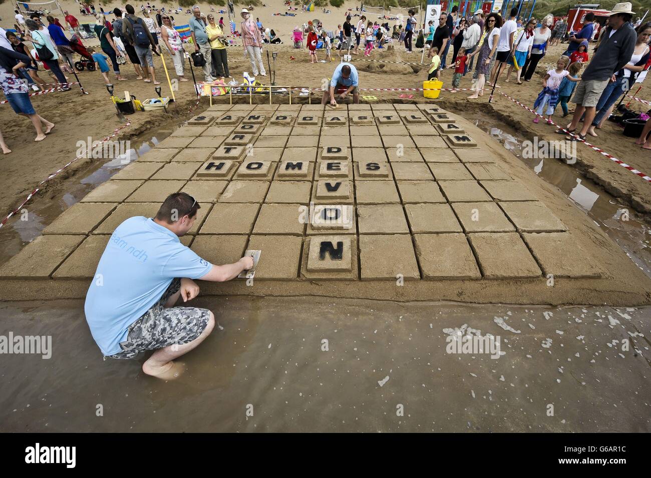 Photo. A Scrabble themed sandcastle sculpture is near completion by the ...