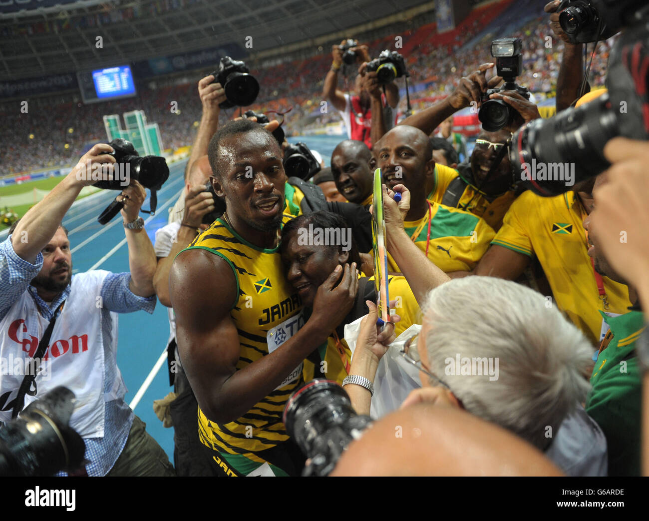 Jamaica's Usain Bolt hugs a girl who got sandwiched between a board and ...