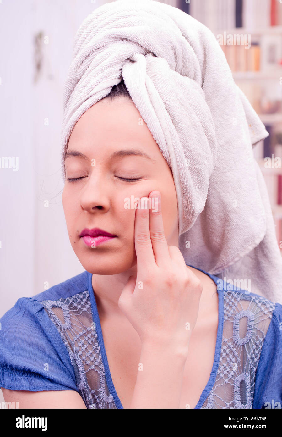 Two fingers covering something in a woman face, towel on her head Stock ...