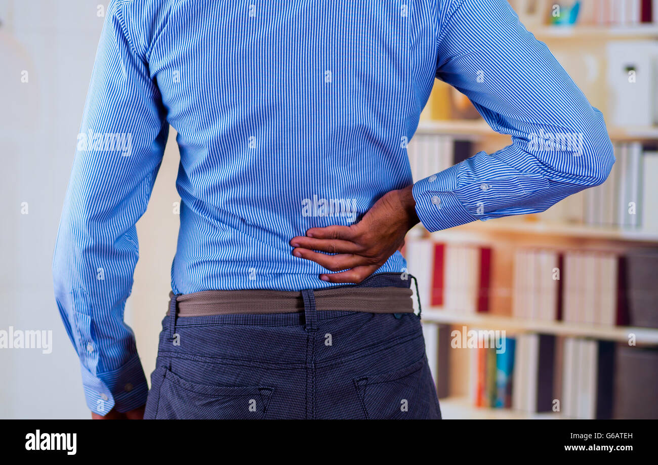 Man touching his back with one of his hand, back pain Stock Photo - Alamy