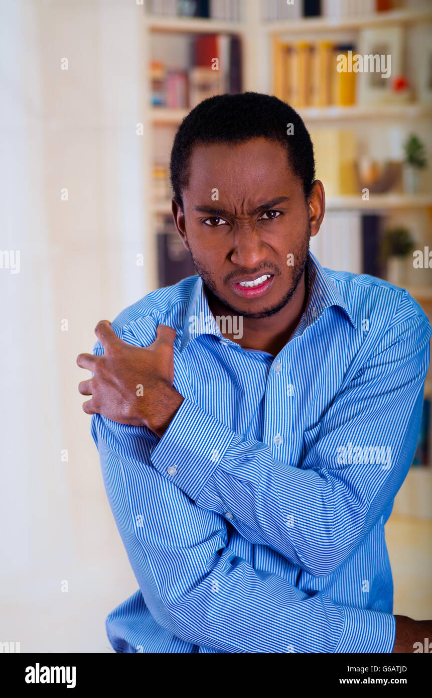 Very hard and strong expression of pain, man holding his shoulder with ...