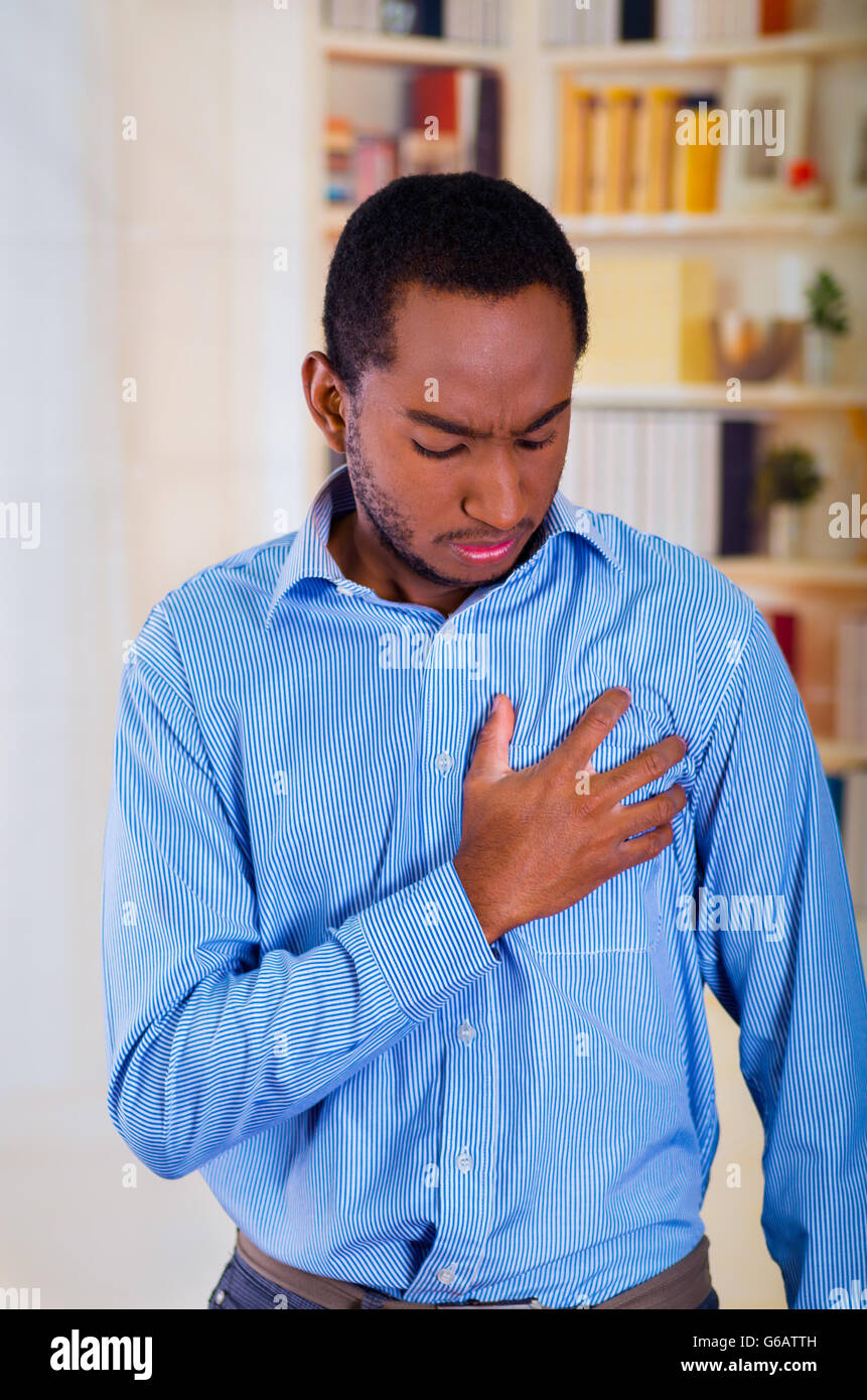 Man with surprised face, look at his chest. Hand is touching where the ...