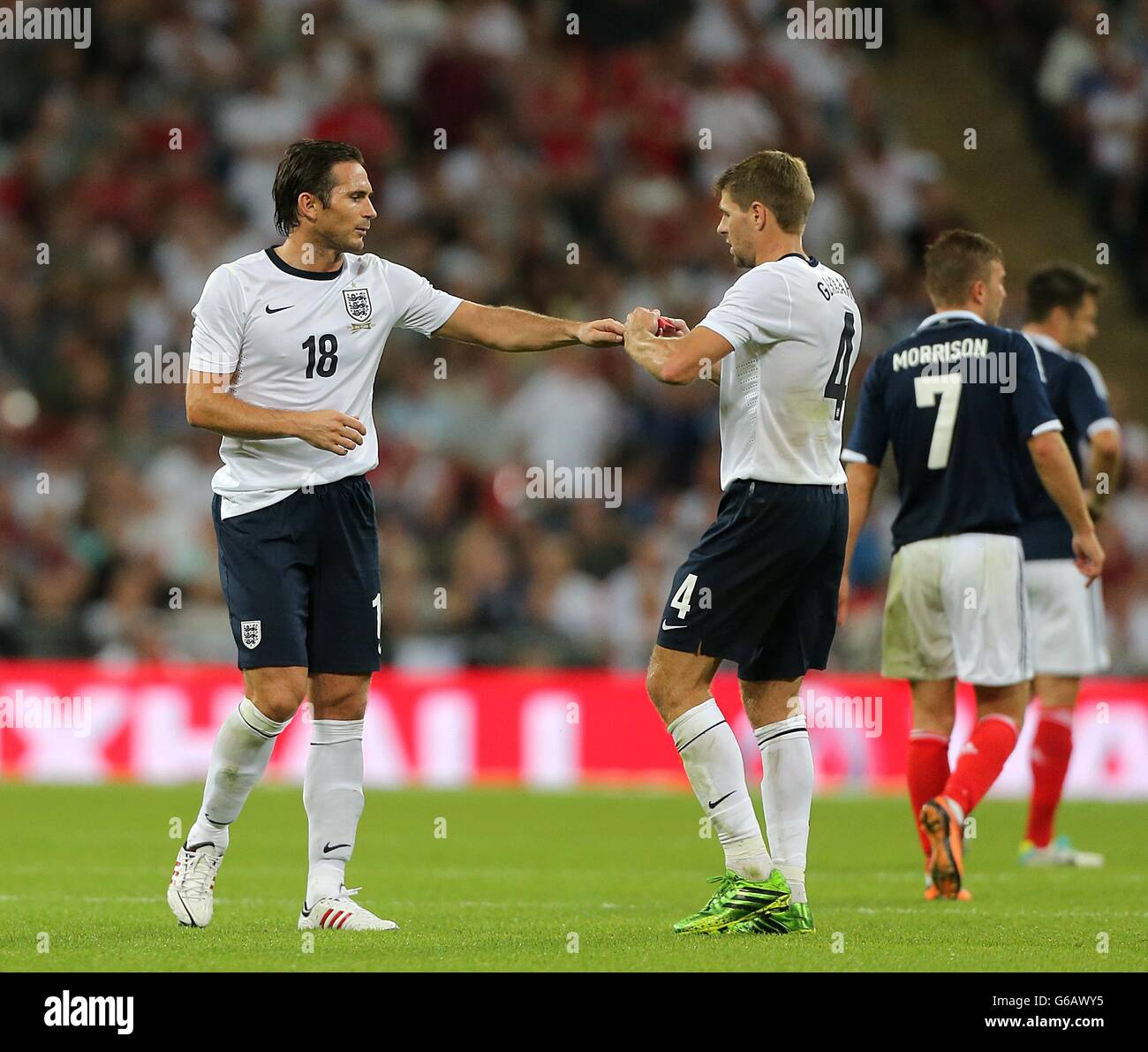 England's captain Steven Gerrard (right) hands the captain's armband ...