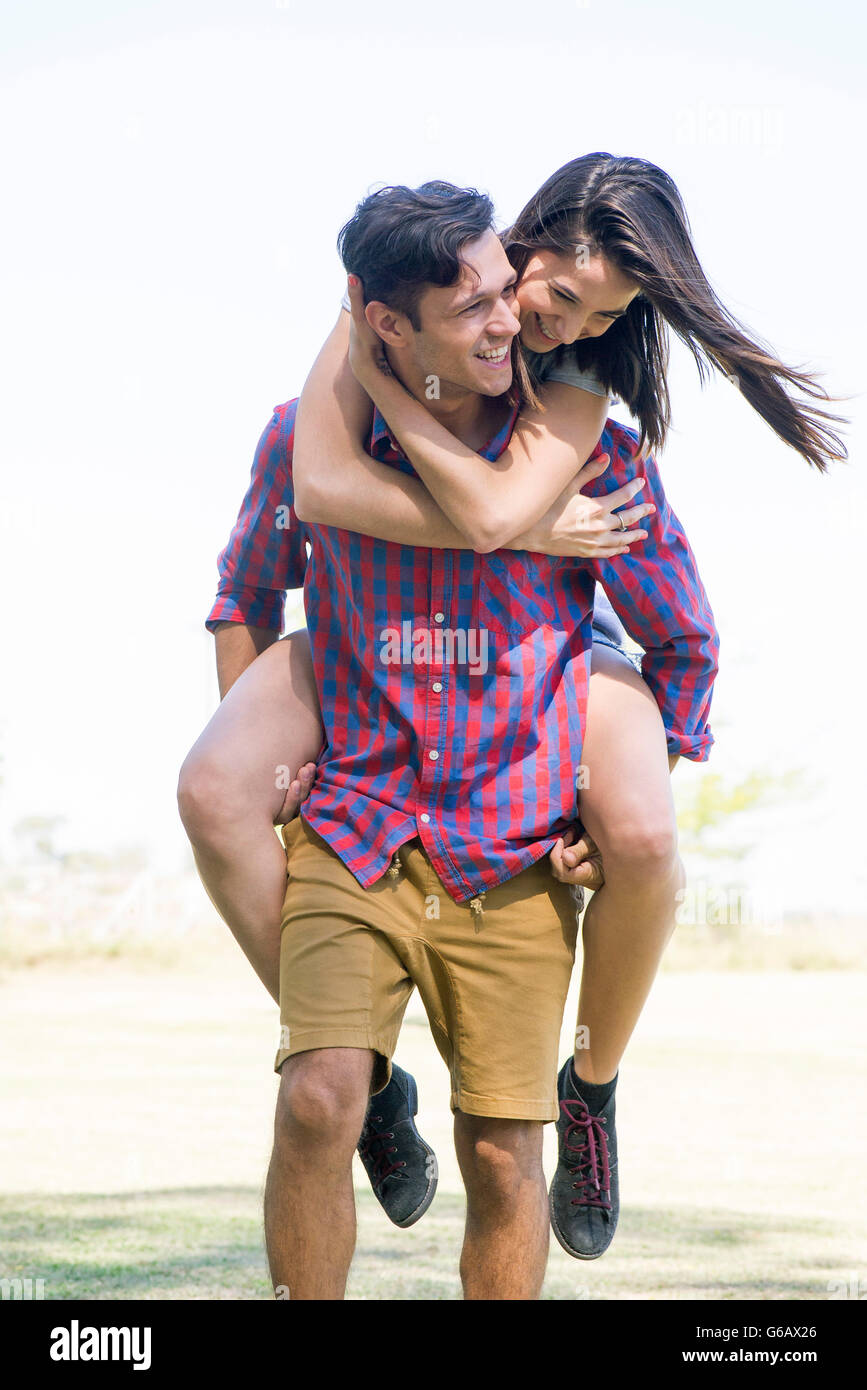 Man giving girlfriend piggyback ride Stock Photo - Alamy
