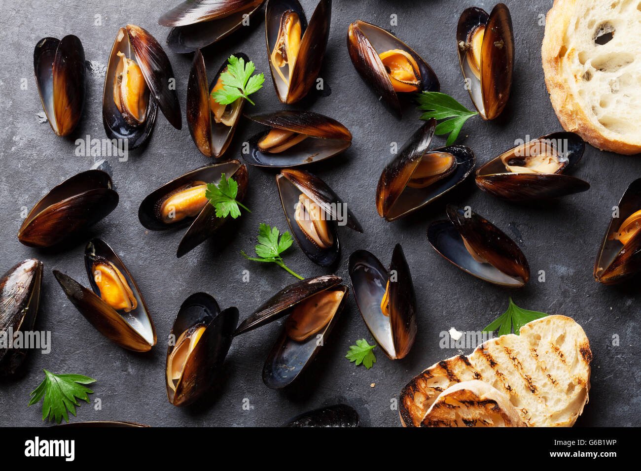Mussels and bread toasts on stone table. Top view Stock Photo - Alamy