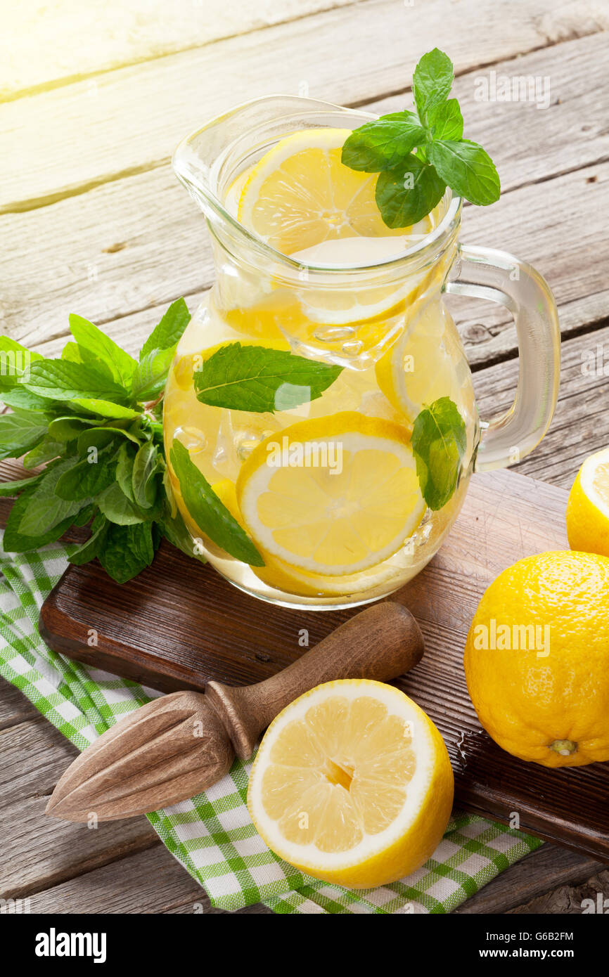 Lemonade pitcher with lemon, mint and ice on garden table Stock Photo ...