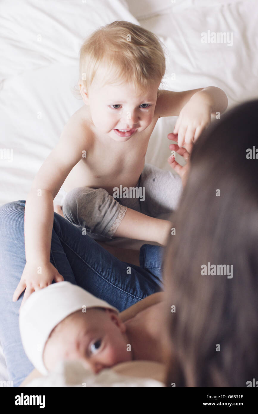 Mother comforting crying child while breast feeding Stock Photo - Alamy