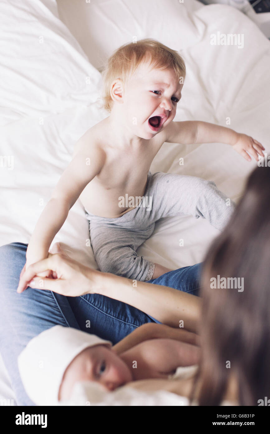 Mother comforting crying child while breast feeding Stock Photo - Alamy
