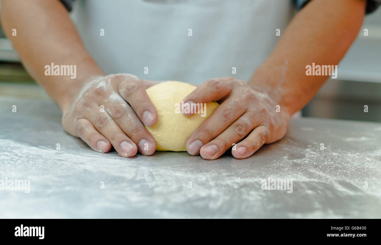 Bakers hands working and kneading bread dough on metal surface Stock ...