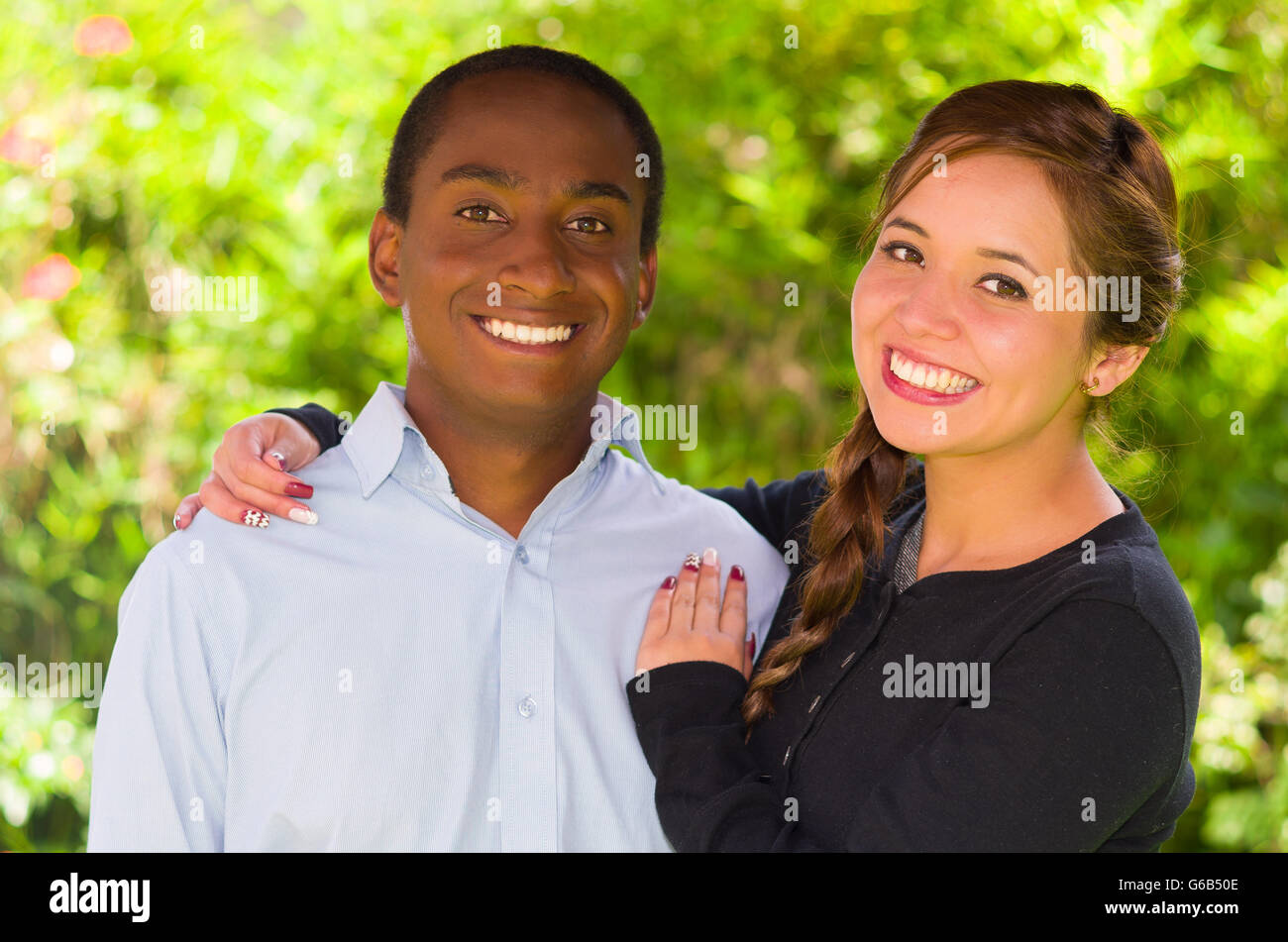 Beautiful young interracial couple in garden environment, embracing and ...