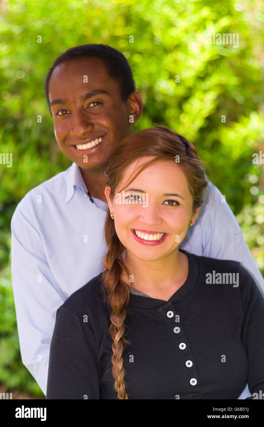 Beautiful Young Interracial Couple In Garden Environment Embracing And