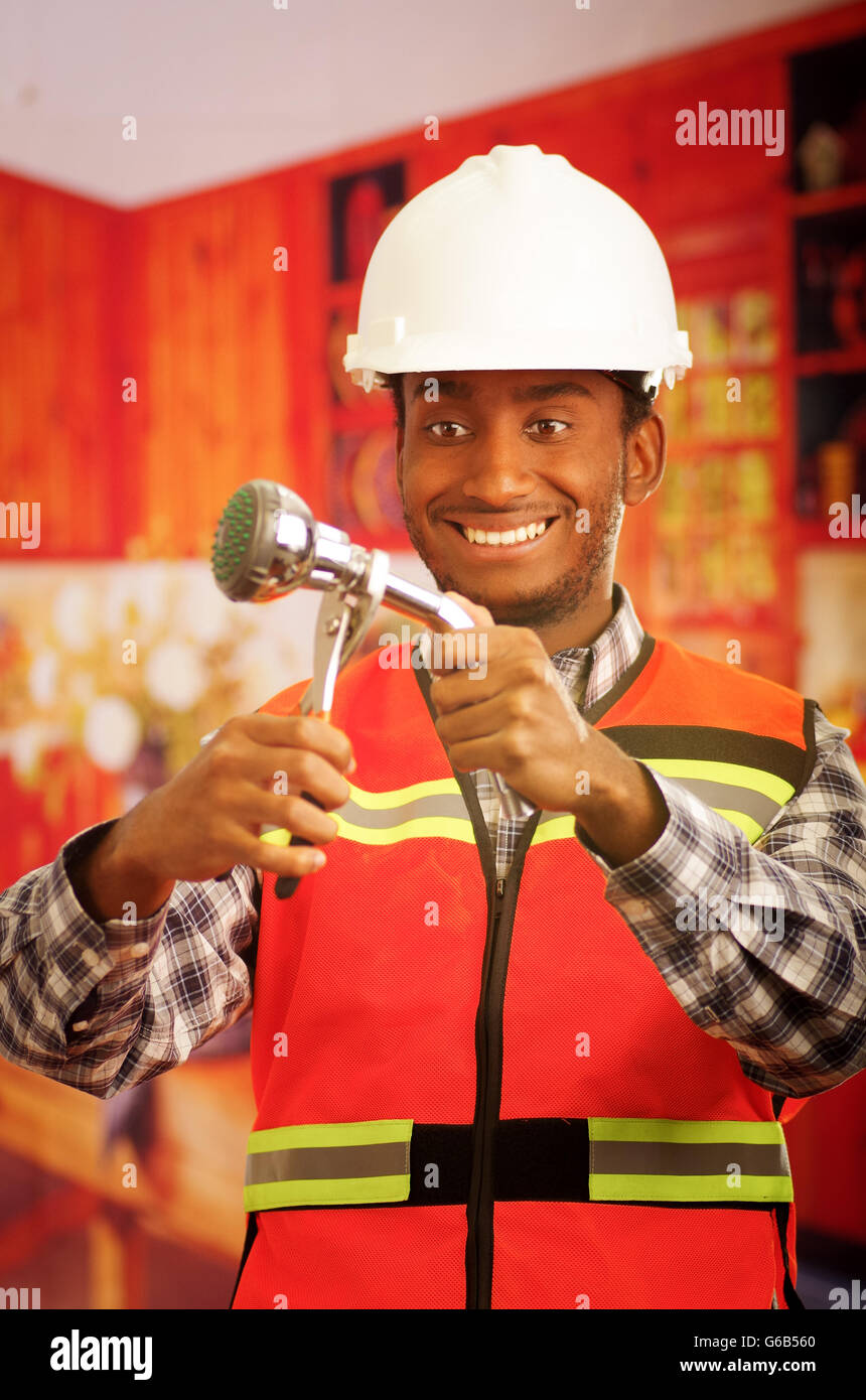 Young engineer wearing square pattern flanel shirt with red safety vest ...