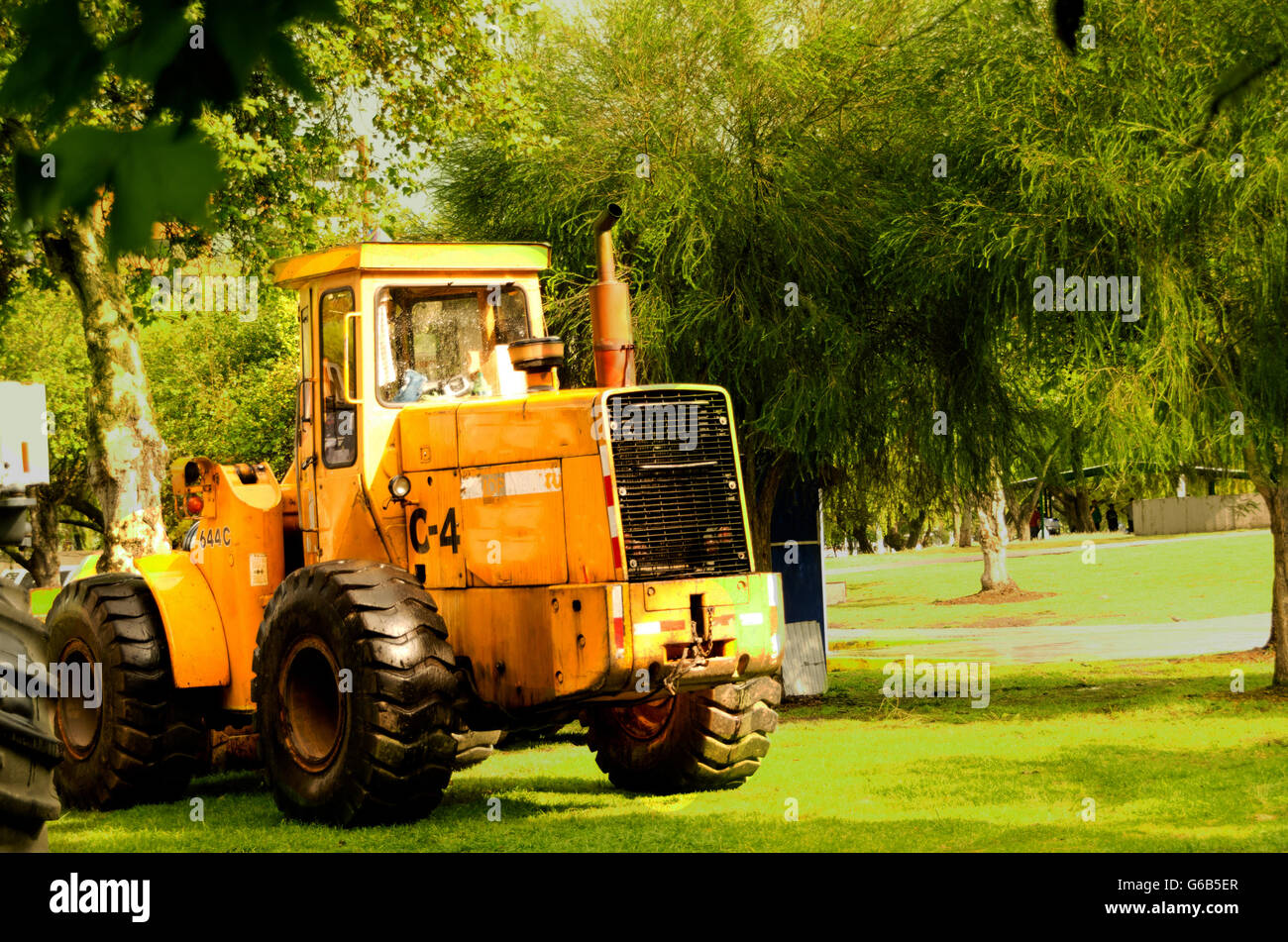 Large yellow bulldozer parked on green grass, very nice color ...