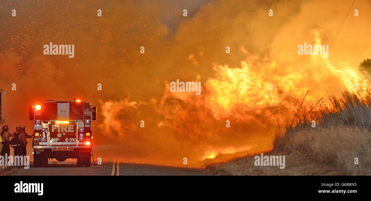 Firefighters from the Lompoc City Fire Department take shelter behind ...