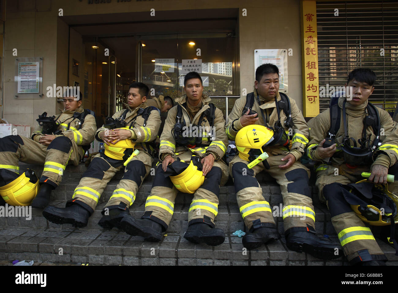 Firefighters gear up and waiting for action next to the burning ...