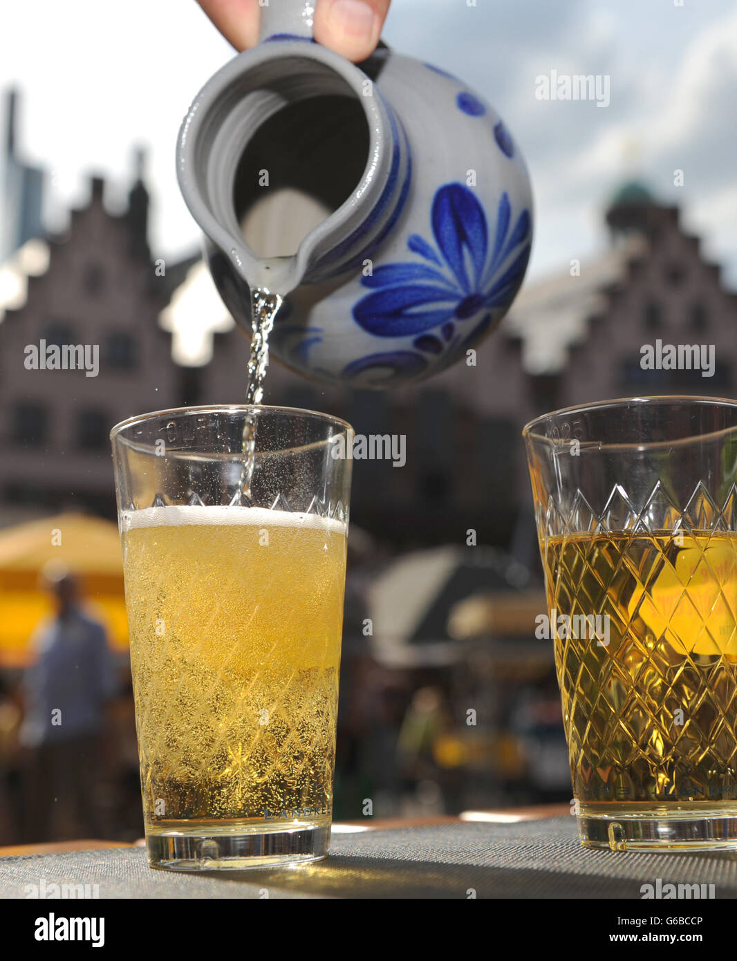 Traditonal apple wine glasses are filled from a traditional "Bembel", a ...