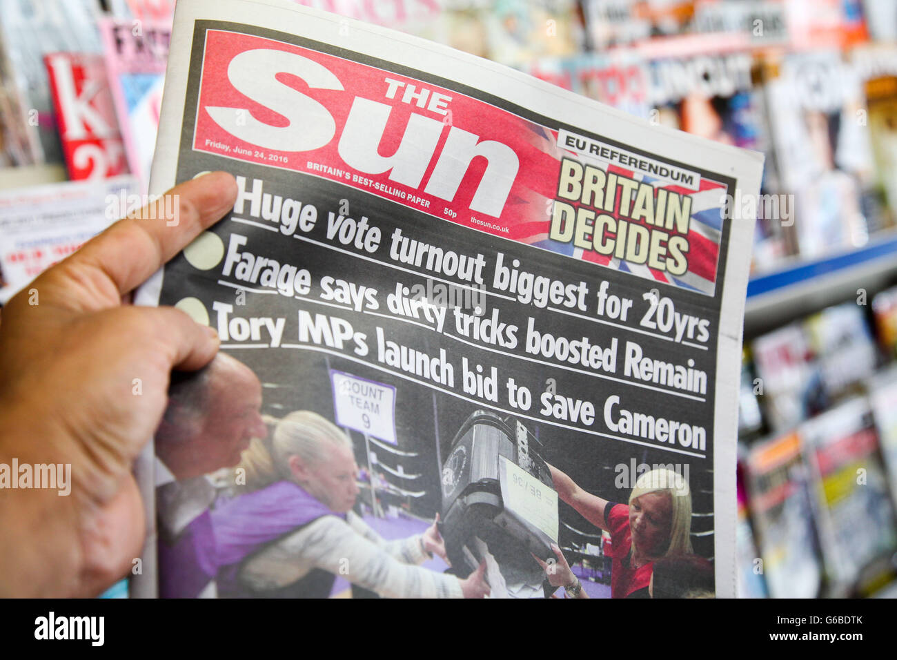 London, UK 24 June 2016 - A reader reads the front page of the The Sun ...