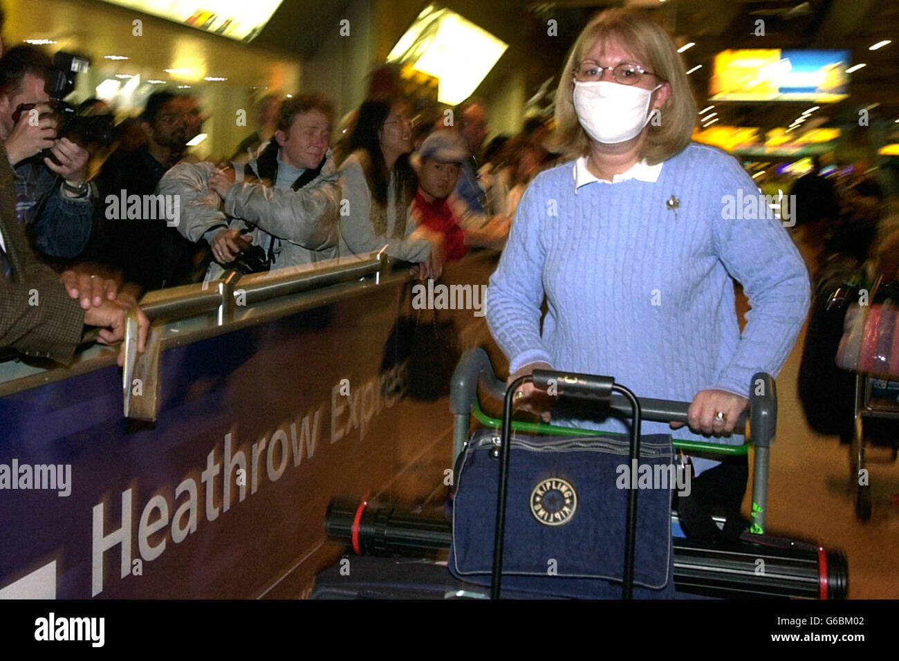 Sandra Perry from Sutton, Surrey, wears a face mask as she arrives back ...