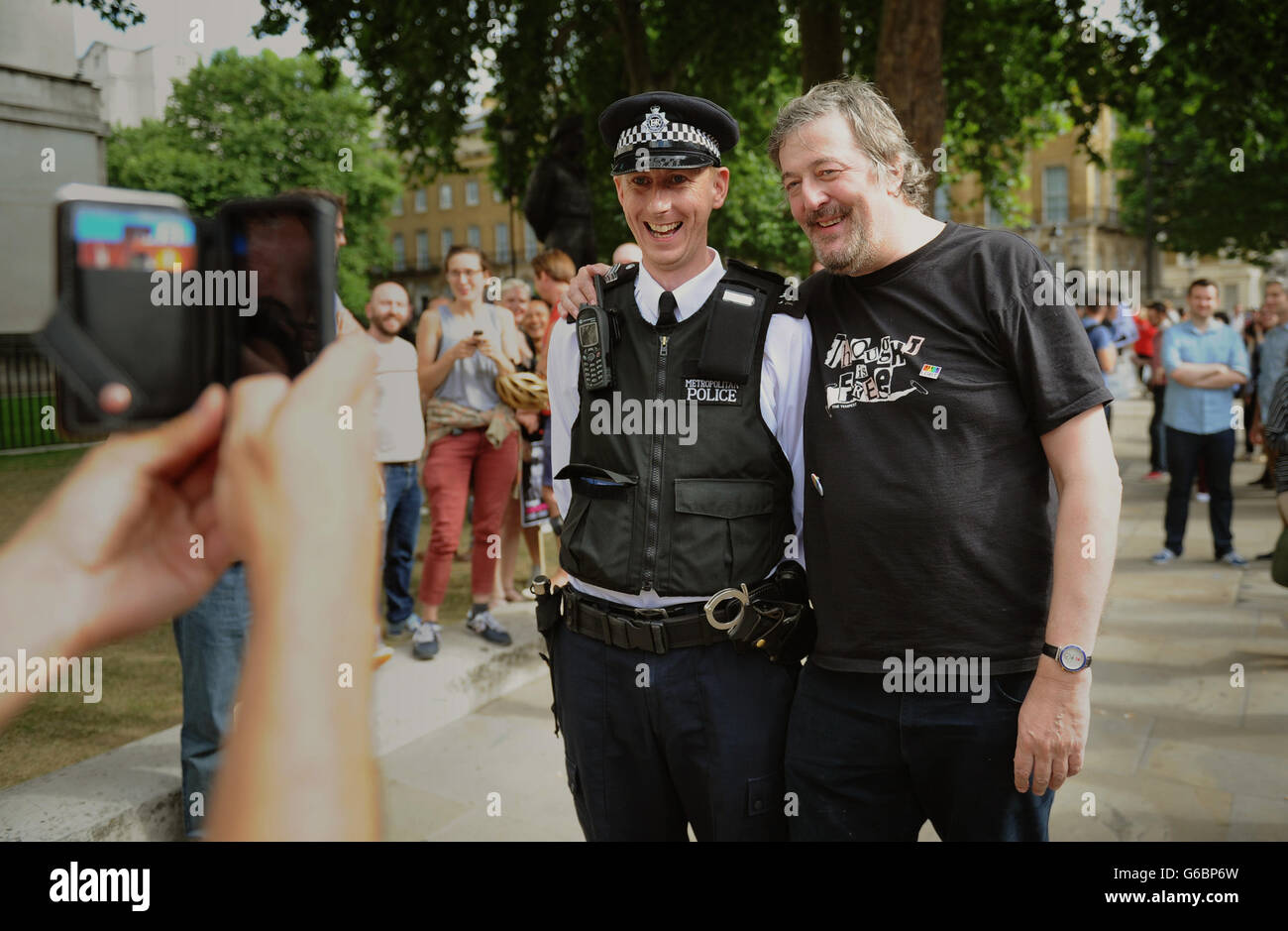 Stephen Fry poses with a police officer after speaking to demonstrators ...