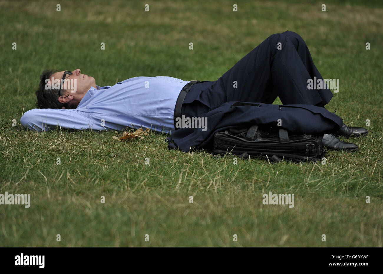 An office worker makes the most of the hot weather as he relaxes in ...