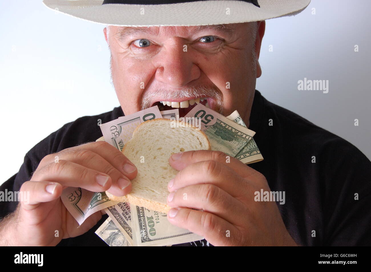 A mean eating money in a sandwich Stock Photo - Alamy