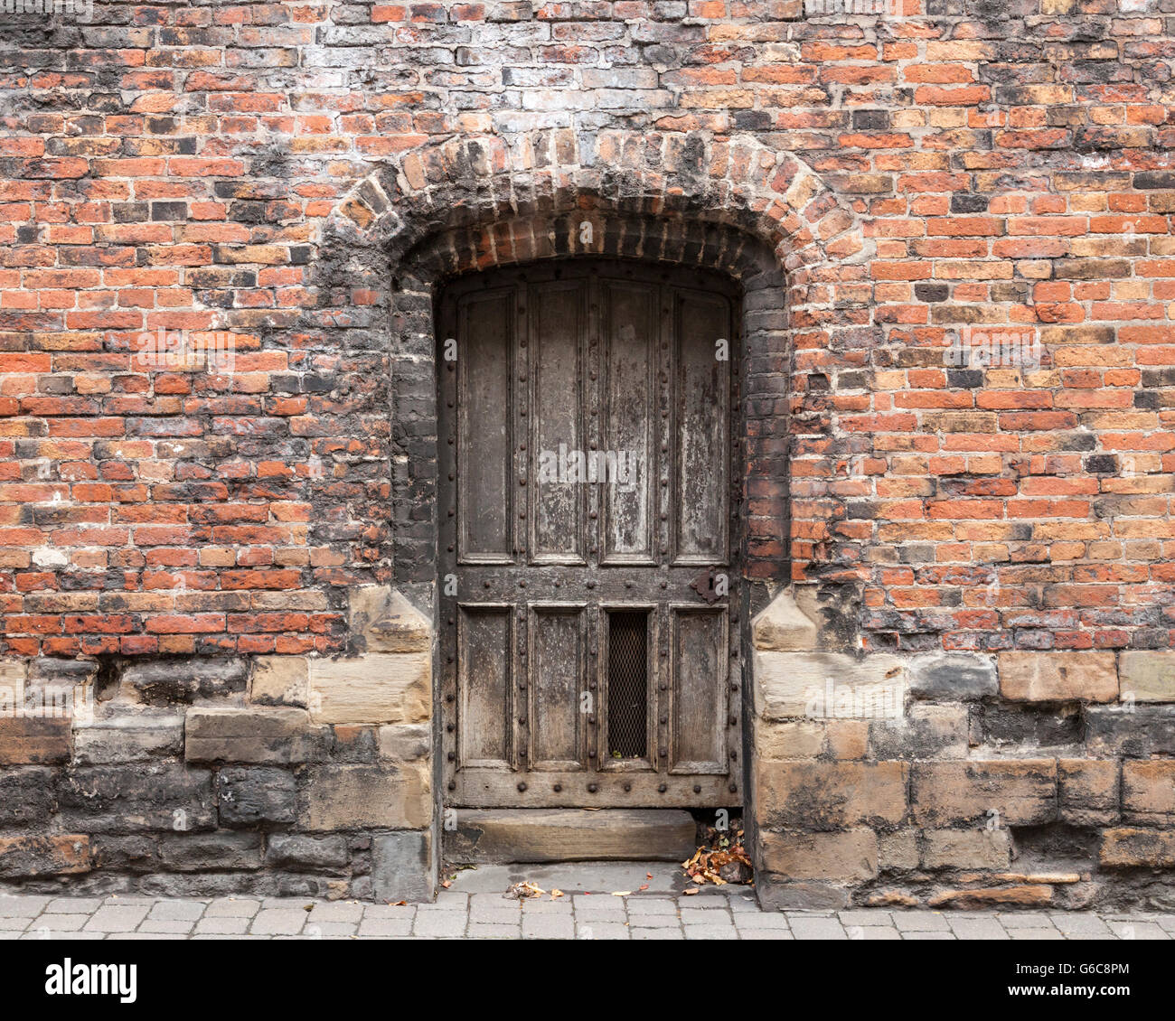 Ancient wooden door in an old brick wall below St Mary's church, Lace ...