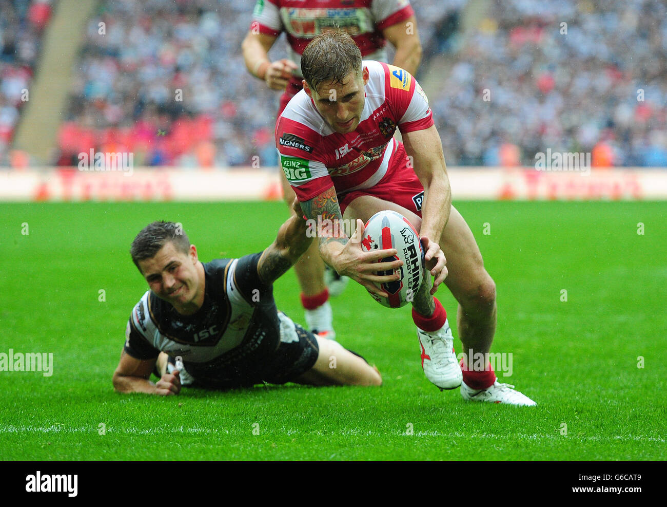 Wigan Warriors' Sam Tomkins (right) beats Hull FC's Jamie Shaul to ...