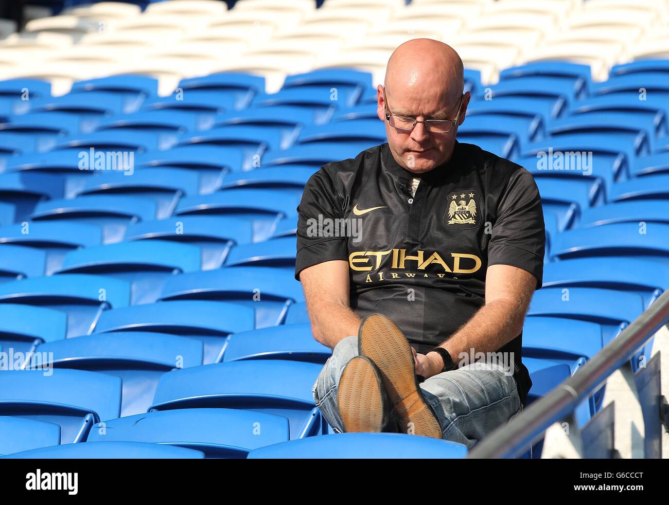 A sad Manchester City fan sits alone in the stands after his team lose ...