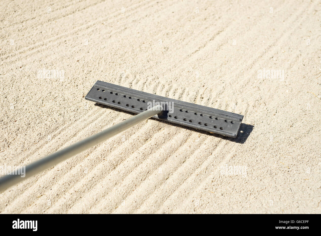 Raking a golf bunker Stock Photo - Alamy