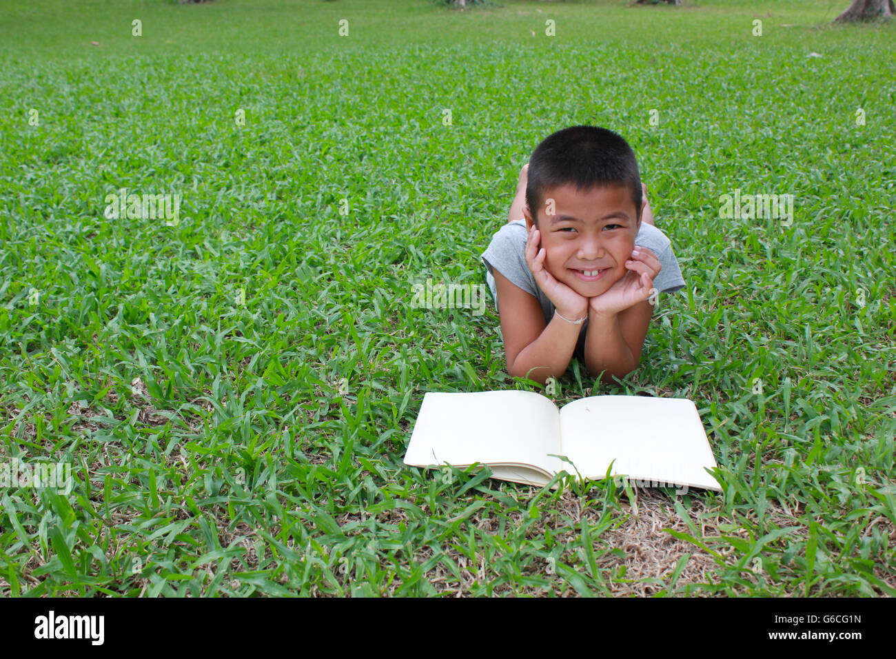 Young boy reading in the park, spring time Stock Photo - Alamy