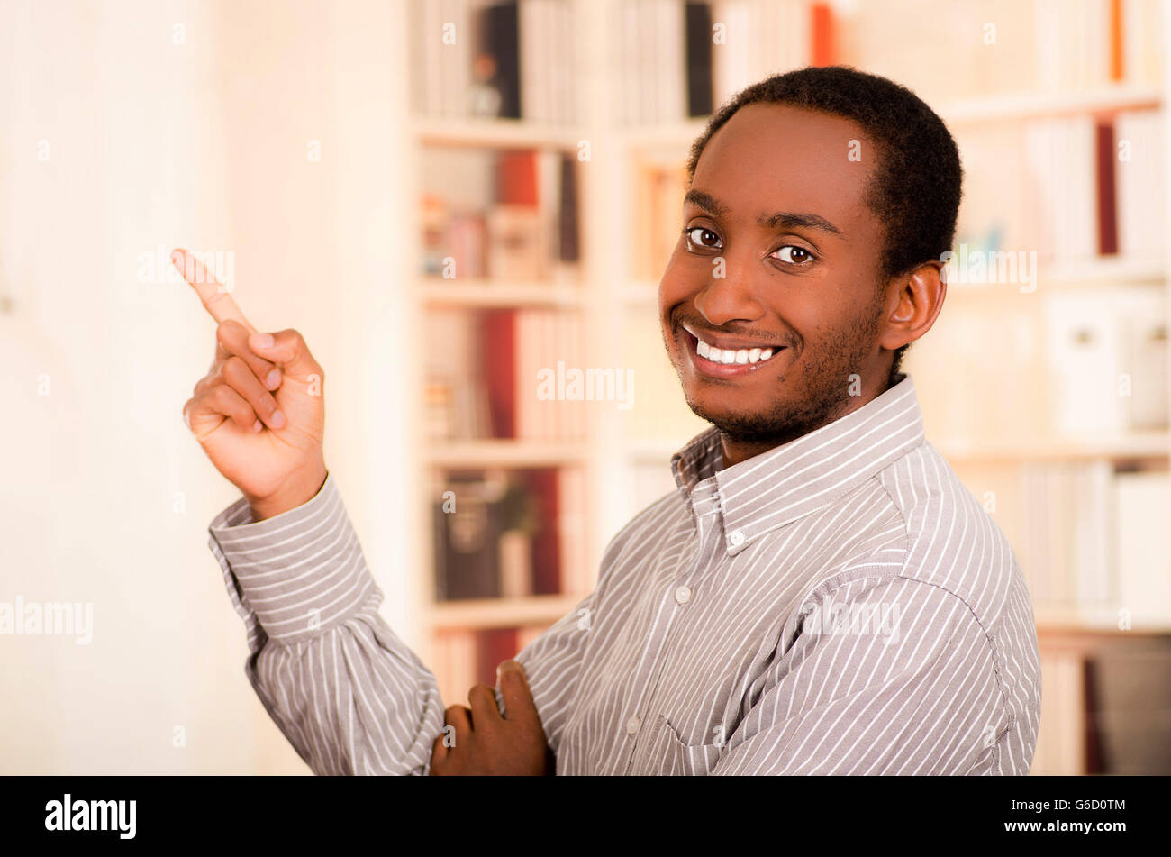 Man wearing casual clothes posing happily for camera, index finger ...