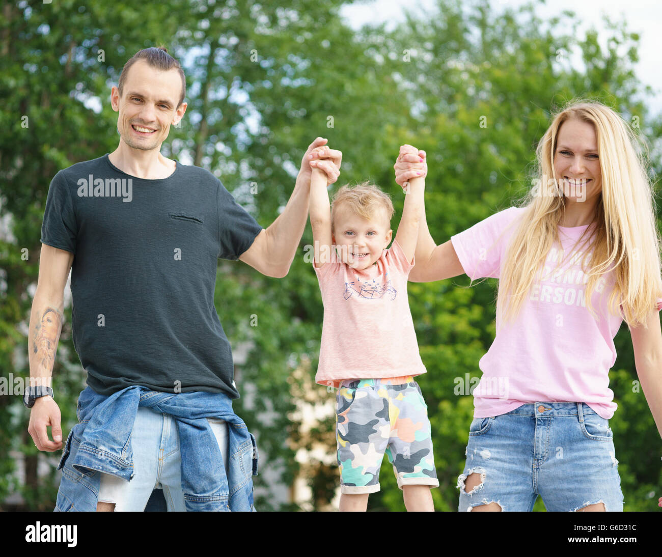 happy family lift up their son Stock Photo - Alamy