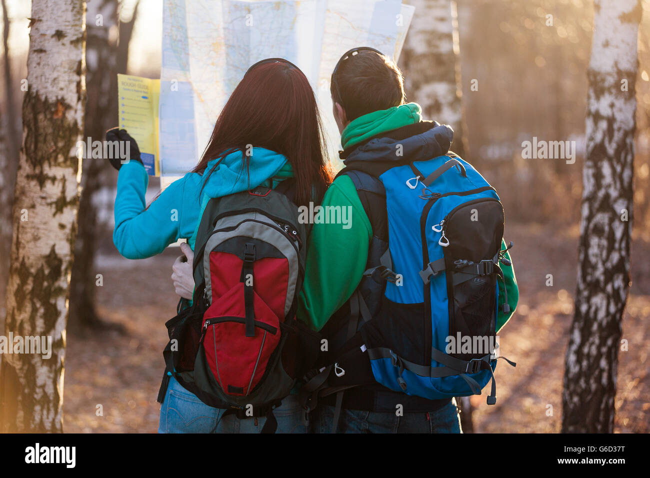 Young couple hikers looking at map Stock Photo - Alamy
