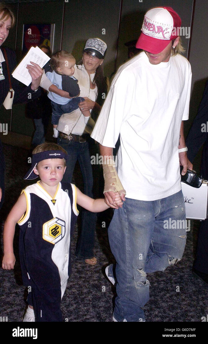 Footballer David Beckham with his son Brooklyn is followed by his wife ...