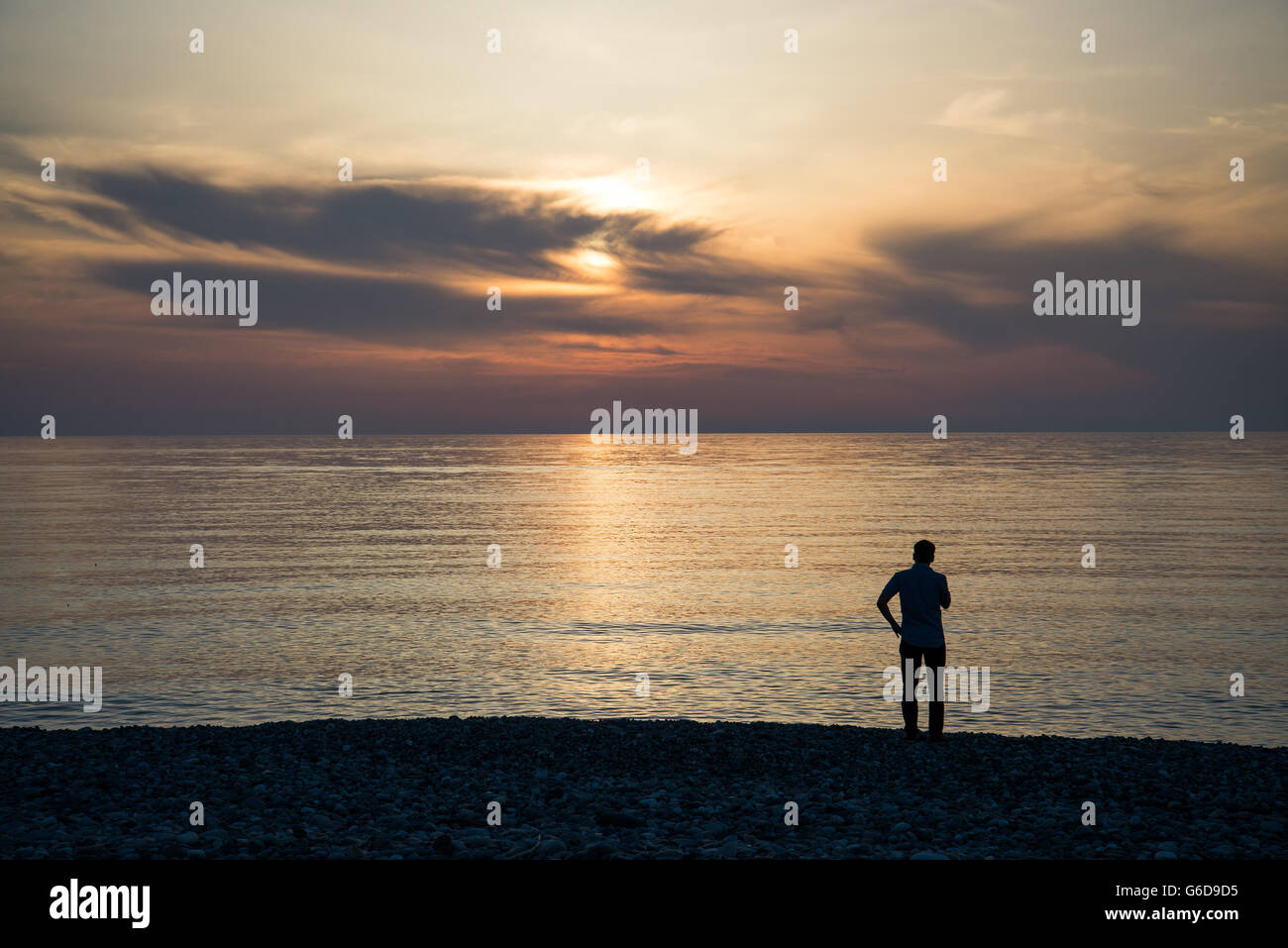 Young man is looking at the sunrise Stock Photo - Alamy