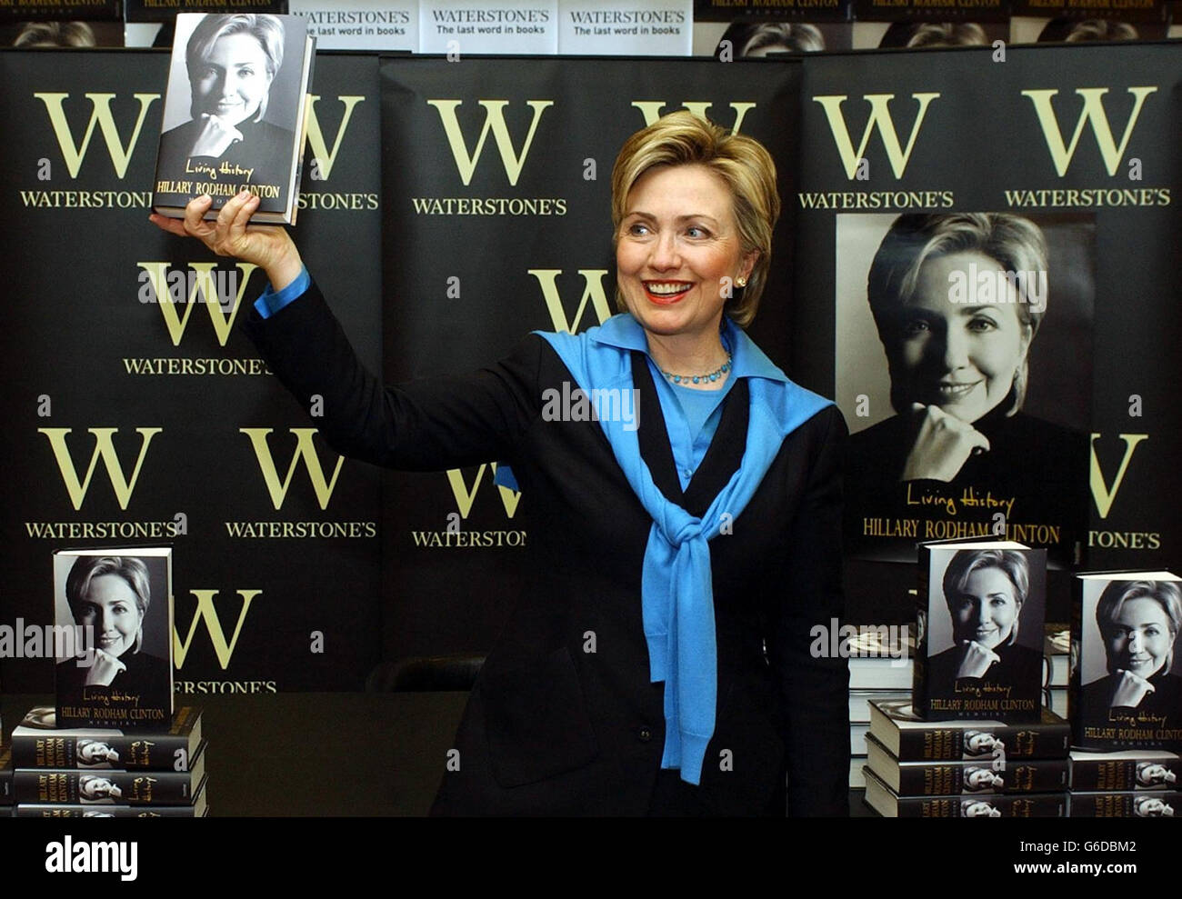 Former US First Lady Hillary Clinton holds a copy of her autobiography ...