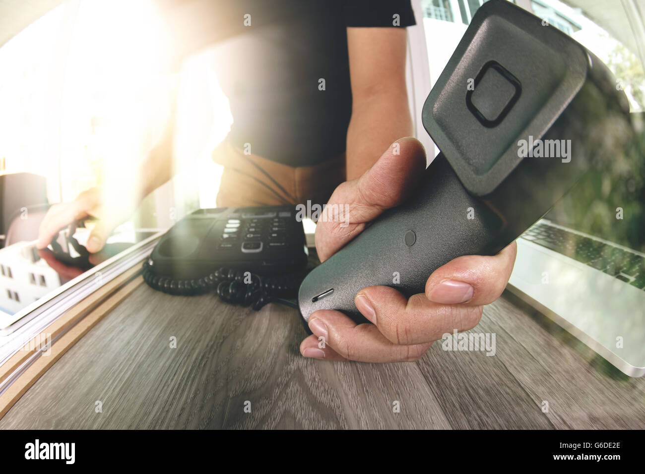 close up of designer hand holding telephone in the office as concept ...