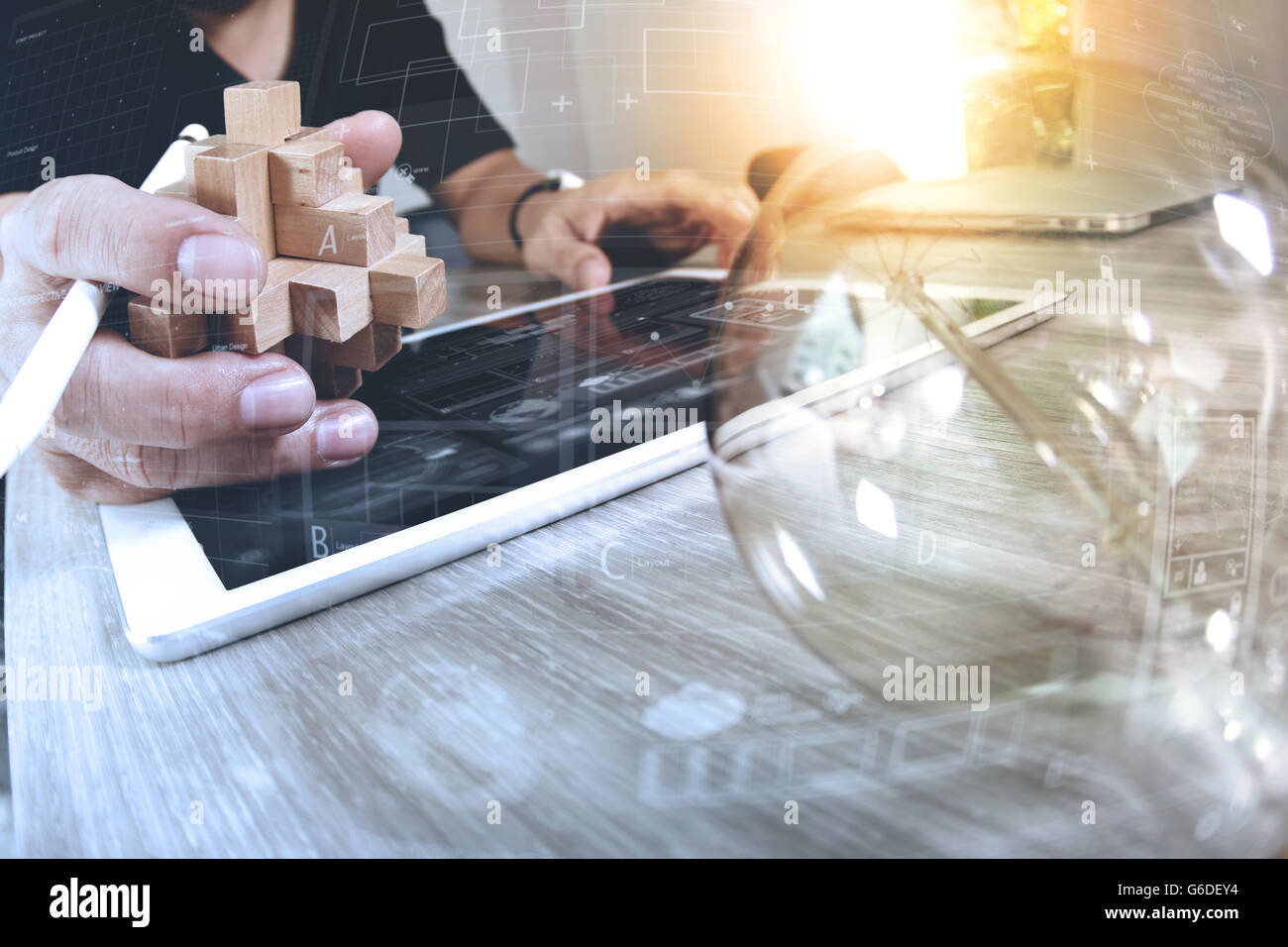 creative hand showing wood puzzle and light bulb with laptop computer ...