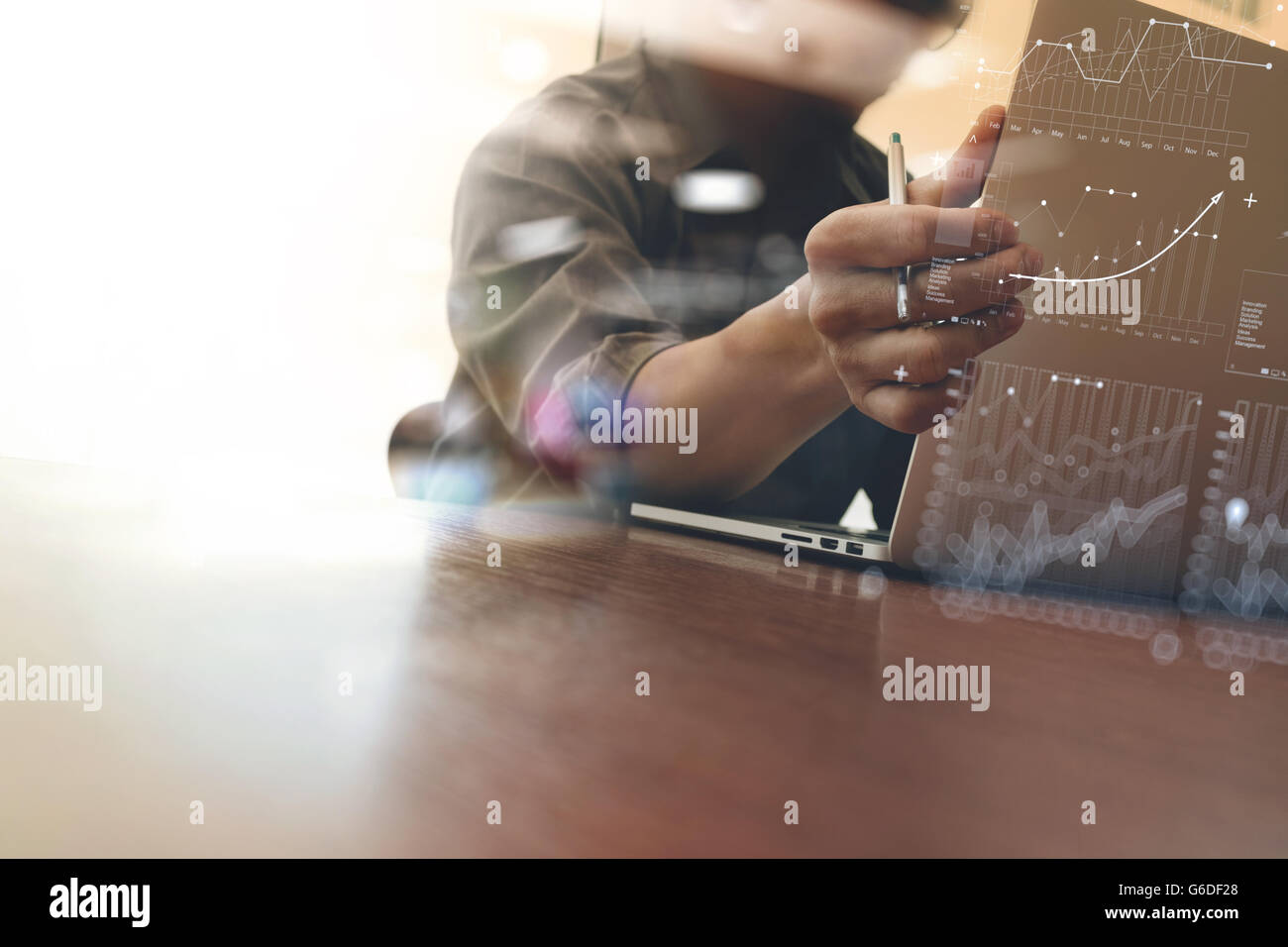 business man hand working on laptop computer with business graph ...