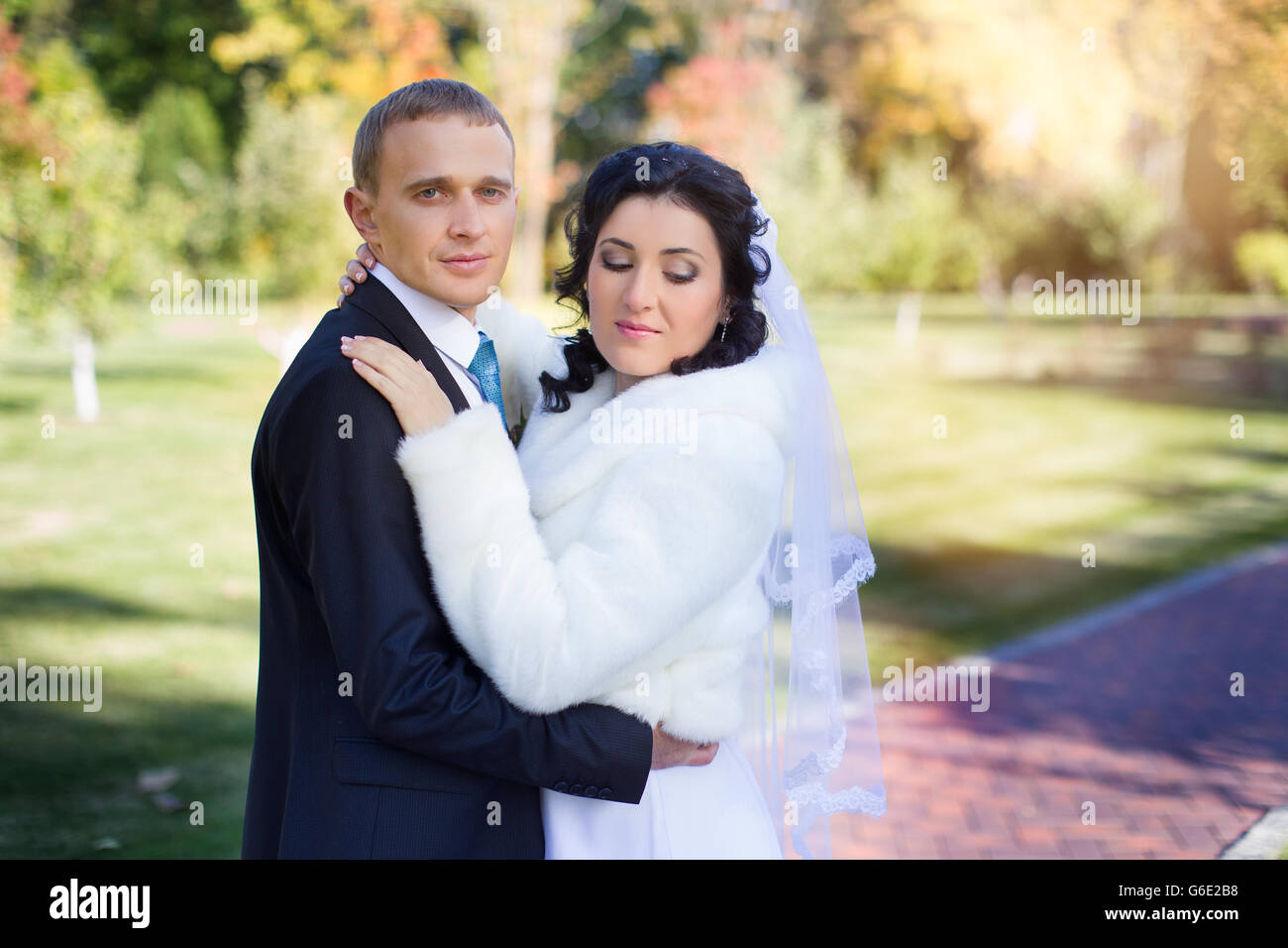 the groom gently embraces and kisses the bride Stock Photo - Alamy
