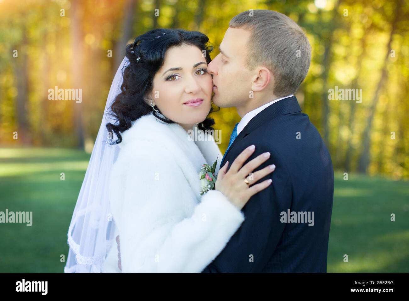 the groom gently embraces and kisses the bride Stock Photo - Alamy