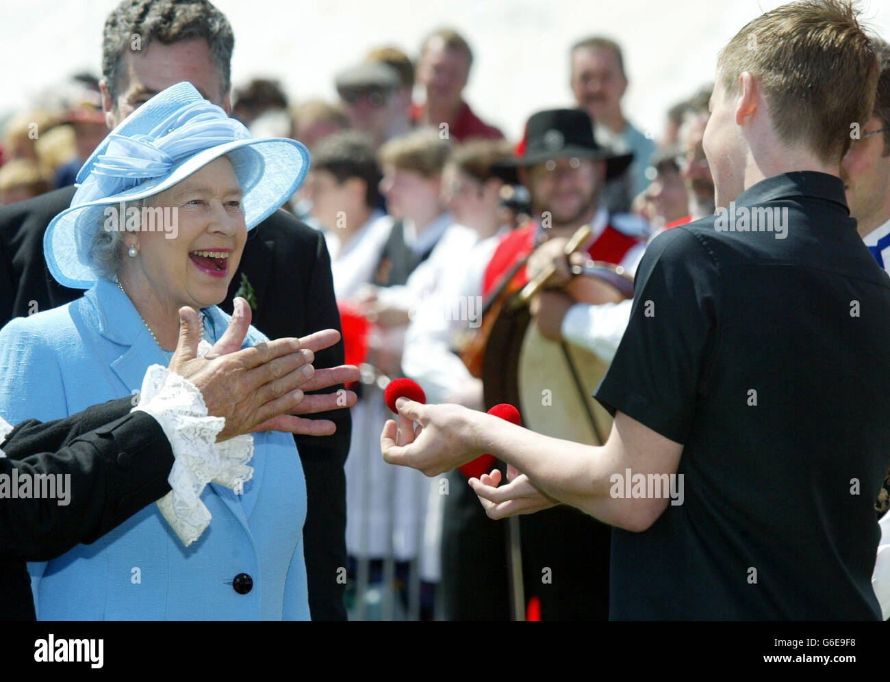 Queen Elizabeth II laughs after being shown a magic trick by a teenage ...