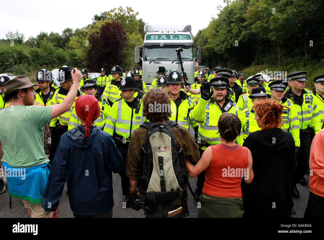 Police officers push back environmental activists as they slow down a ...