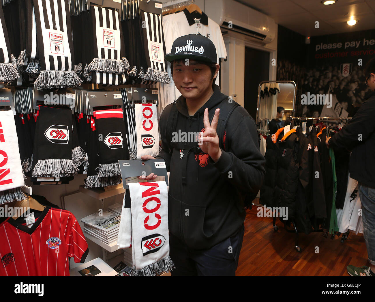 A Fulham fan poses for a photograph inside the club shop Stock Photo ...